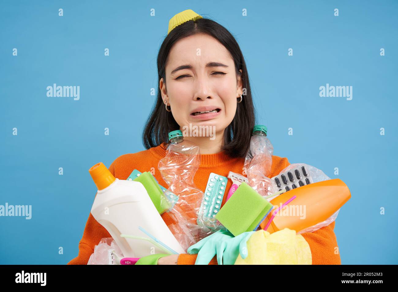 Portrait of crying sad girl with plastic trash, collects recycling ...