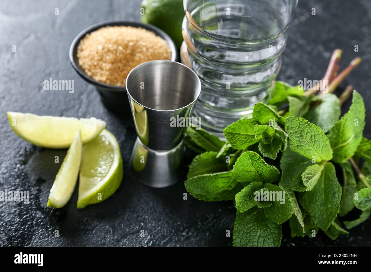 Glass, measure cup and ingredients for preparing mojito on dark background Stock Photo - Alamy