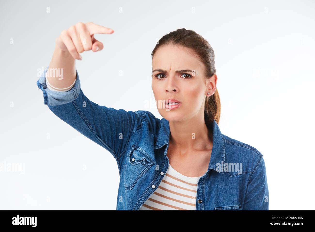 Dont you dare do that. Studio portrait of a young woman pointing a ...