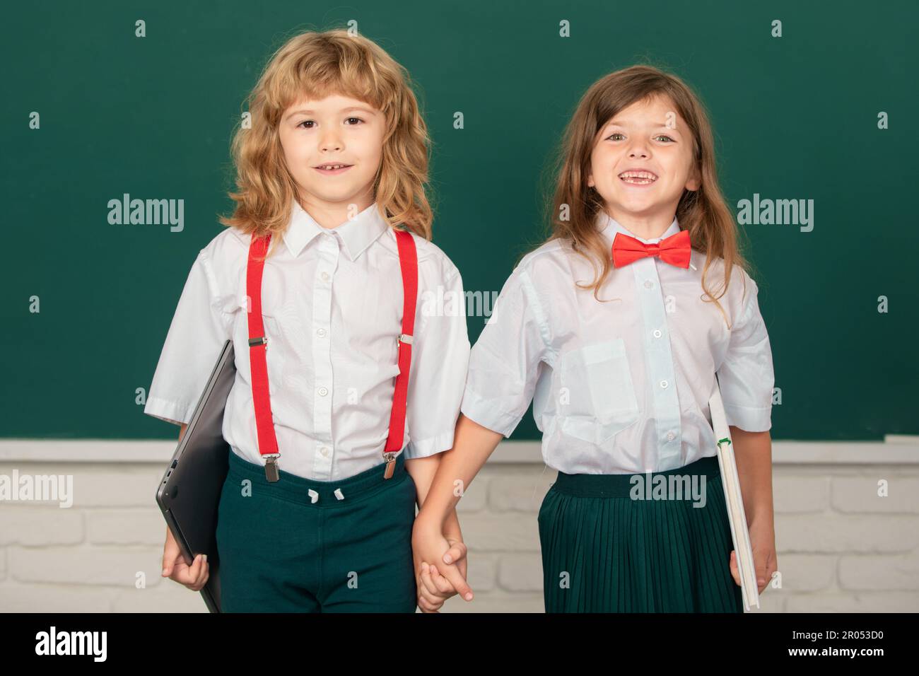 Cute little school kids friends studying together in classroom ...