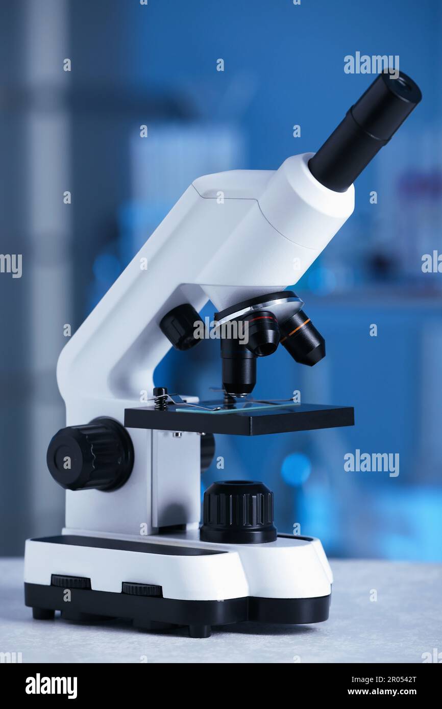 Modern medical microscope on gray table in laboratory Stock Photo - Alamy
