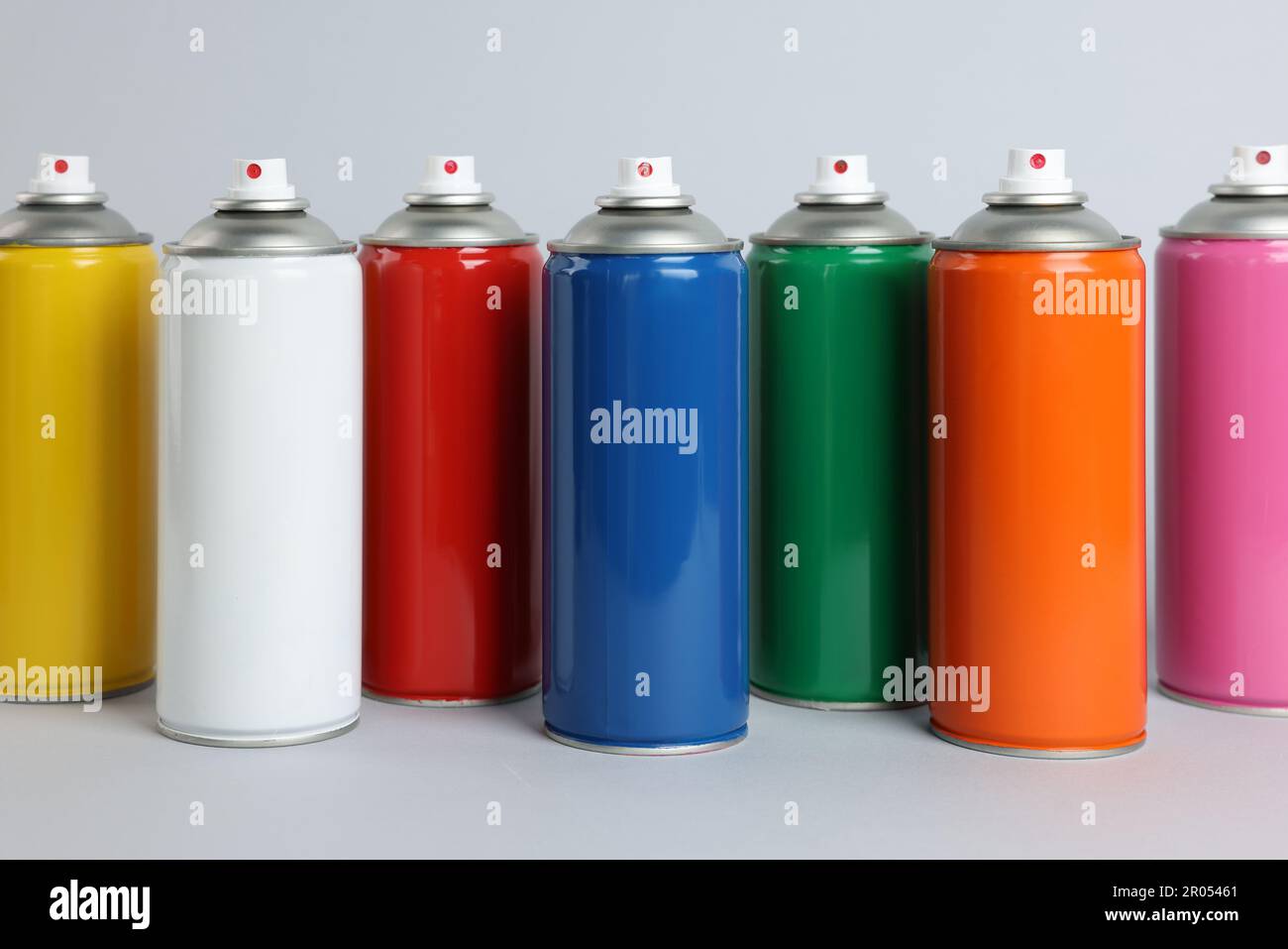 Colorful cans of spray paints on light grey background Stock Photo - Alamy