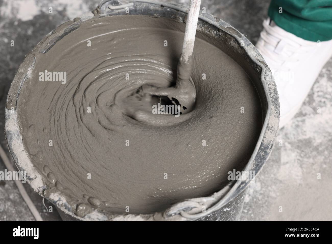 Person mixing cement in bucket hi-res stock photography and images - Alamy