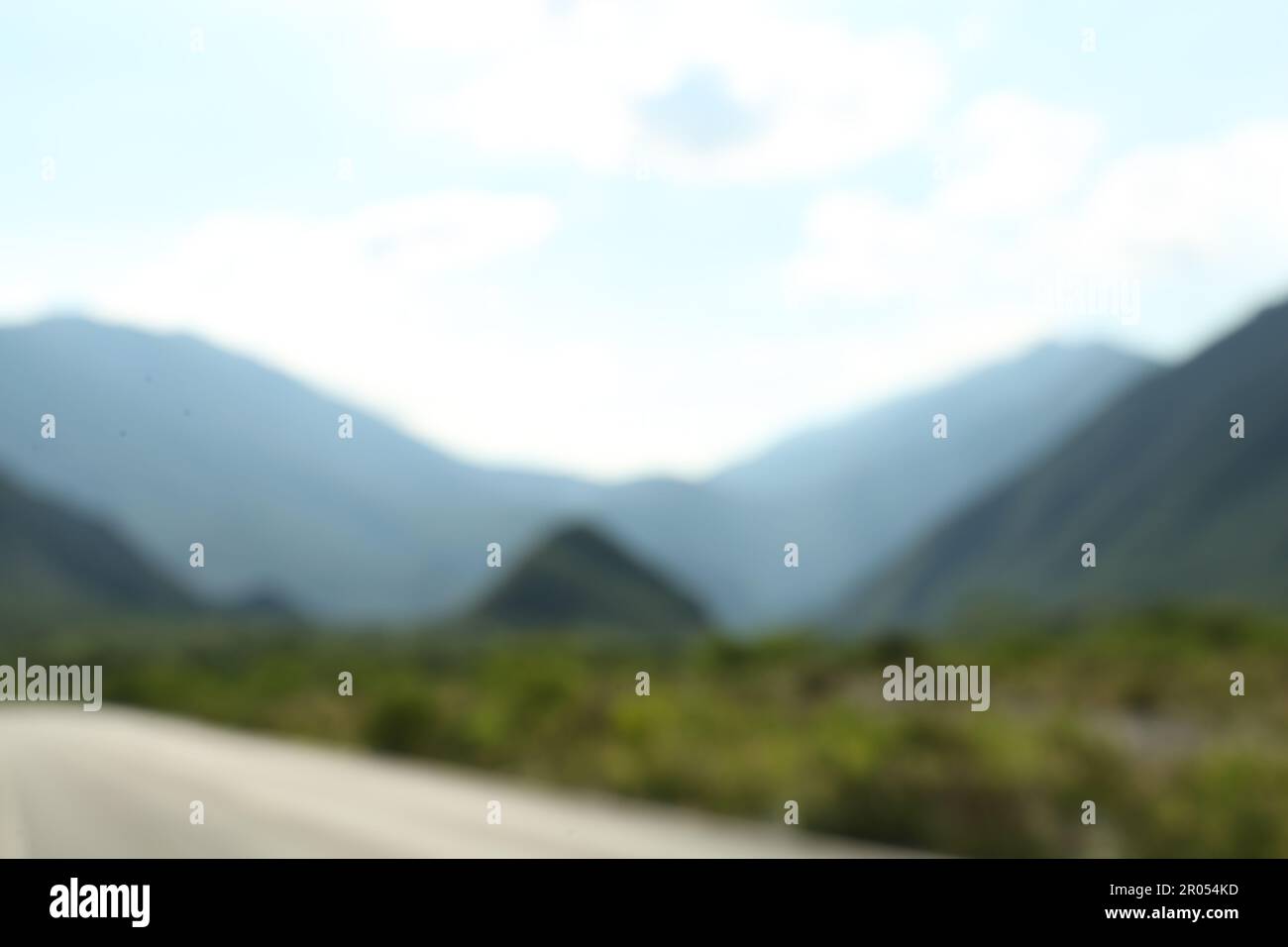 Blurred view of mountains and empty asphalt highway outdoors. Road trip ...