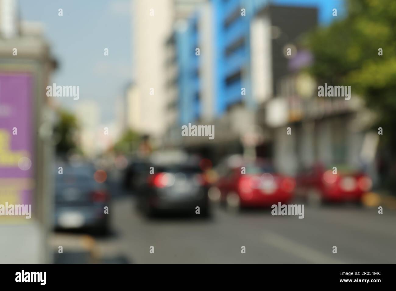 Blurred view of city street with buildings and parked cars Stock Photo ...