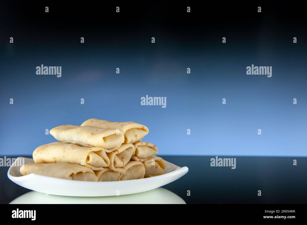 front view rolled sweet pancakes inside plate on light dark background ...