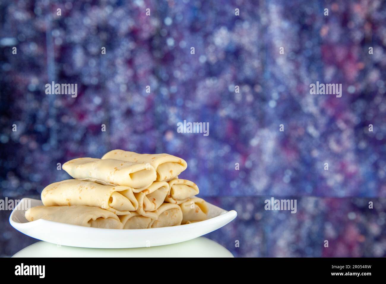front view rolled sweet pancakes inside plate on purple background ...