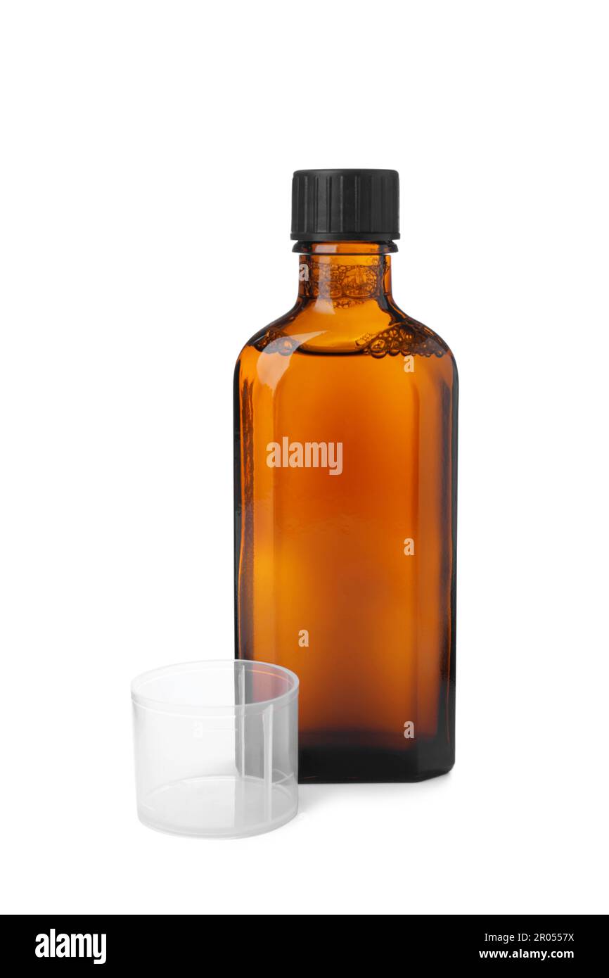 Bottle of syrup with measuring cup on white background. Cough and cold ...