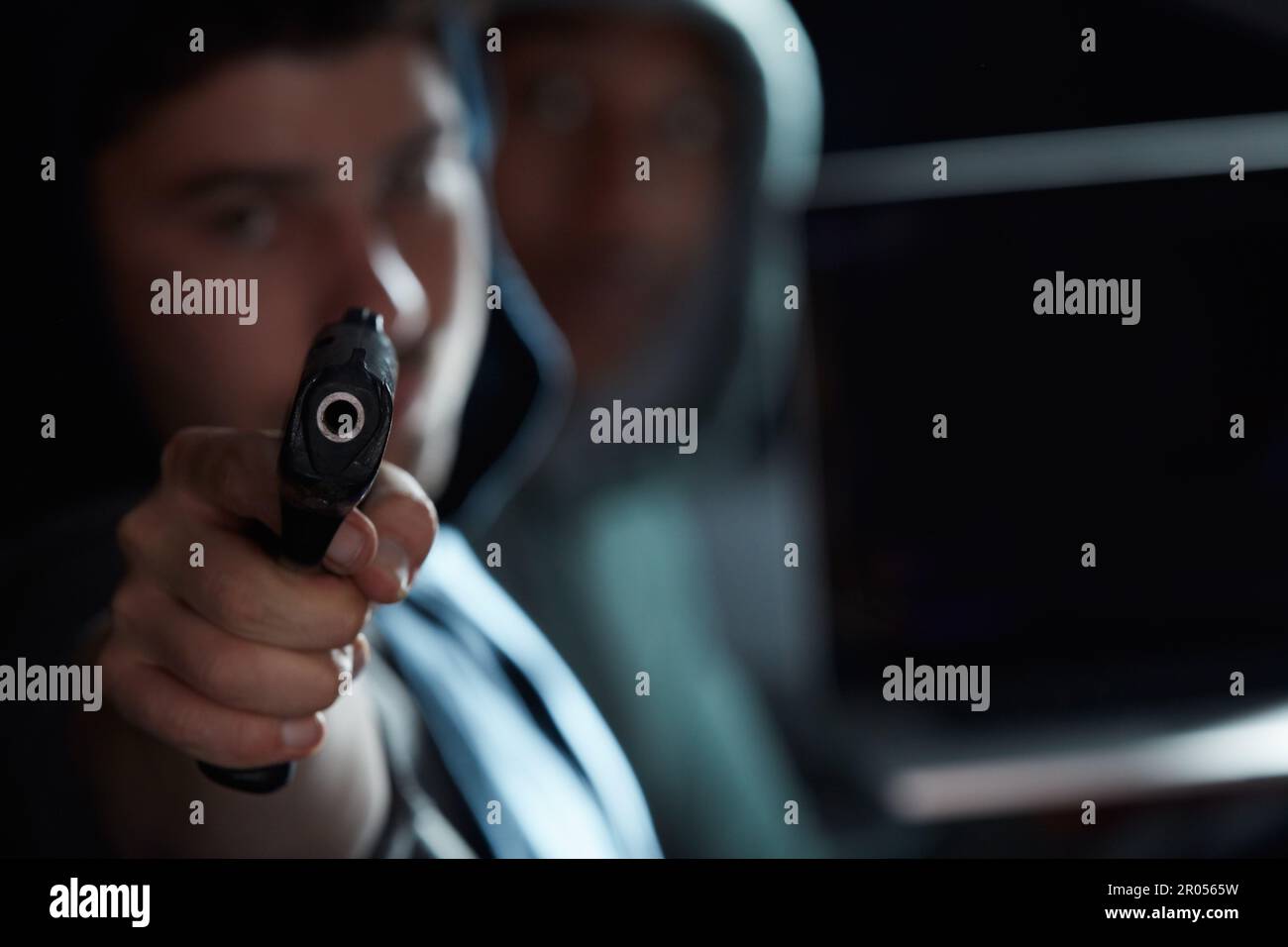 Dont move. two men sitting in a car and pointing a gun Stock Photo - Alamy