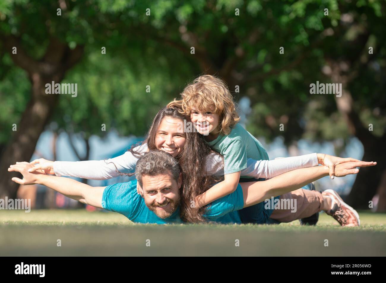 Mother father and child son hugging and embracing outdoors at summer ...