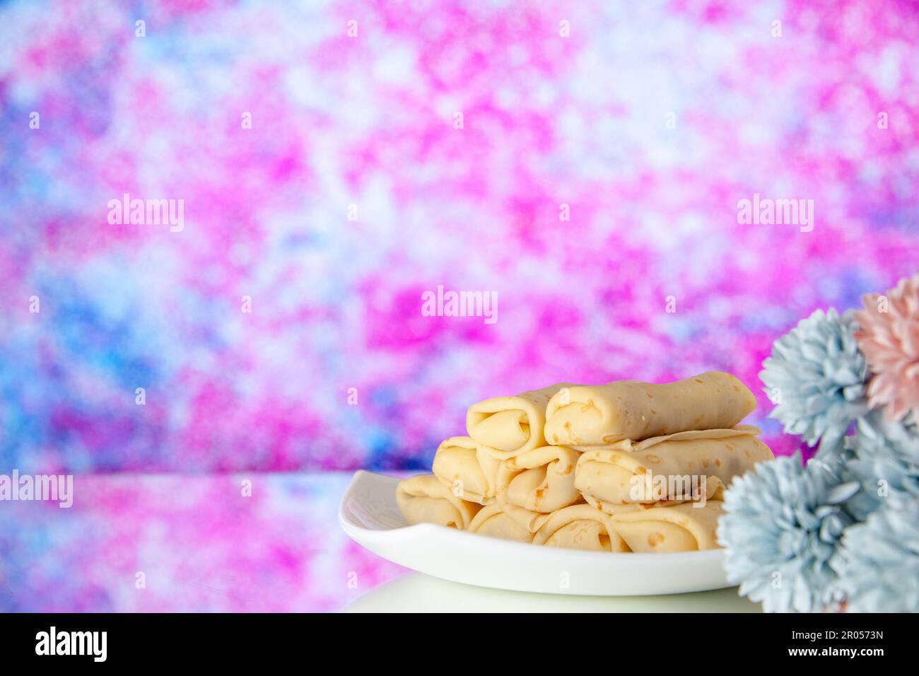front view yummy rolled pancakes on light pink background breakfast ...