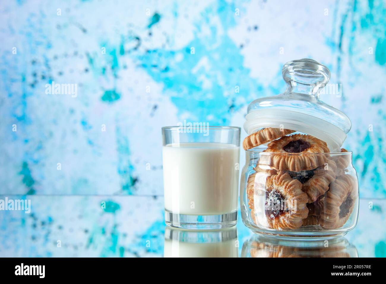 front view yummy sweet biscuits inside can with glass of milk on light ...