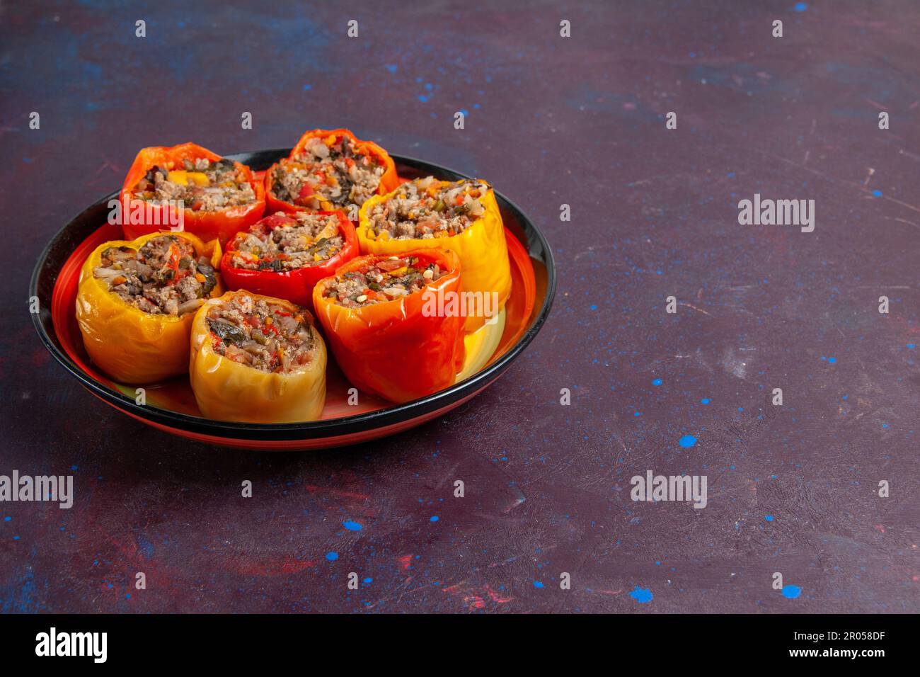 front view cooked bell-peppers with ground meat inside plate on dark ...