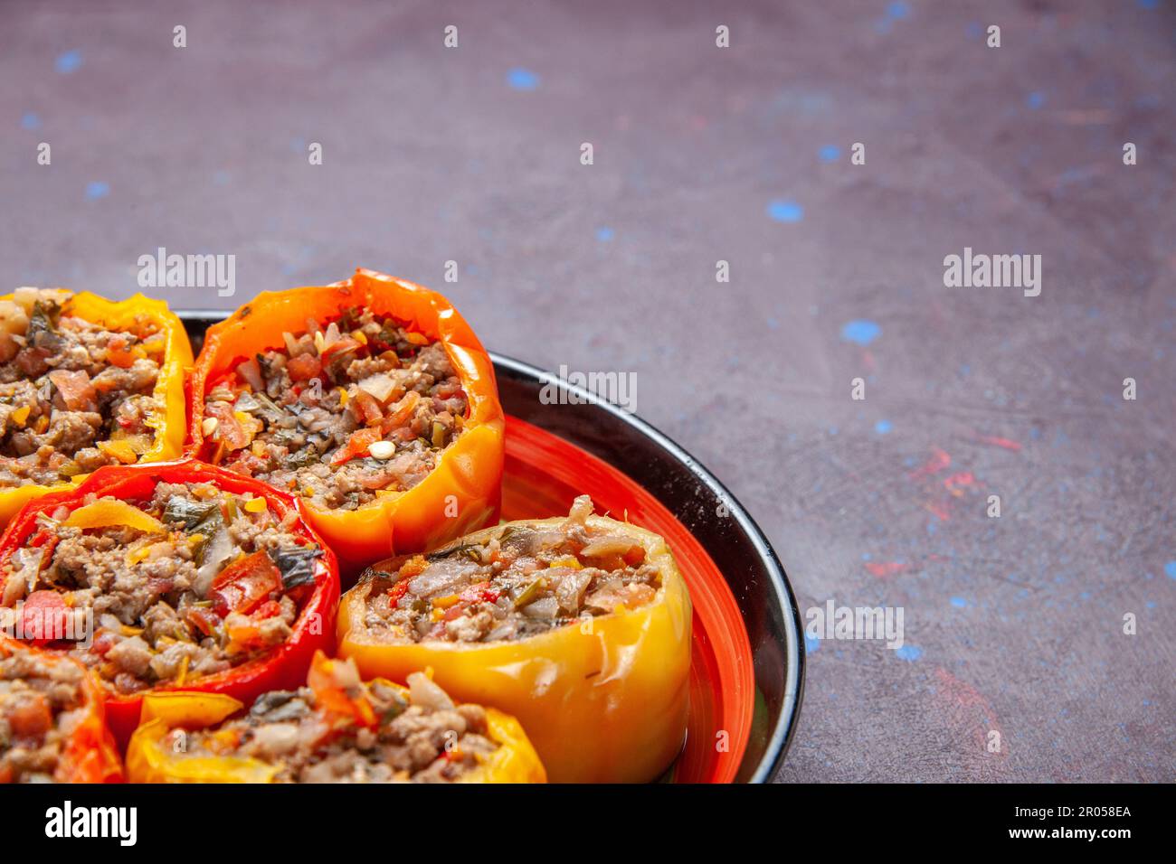 front view cooked bell-peppers with ground meat inside plate on dark ...