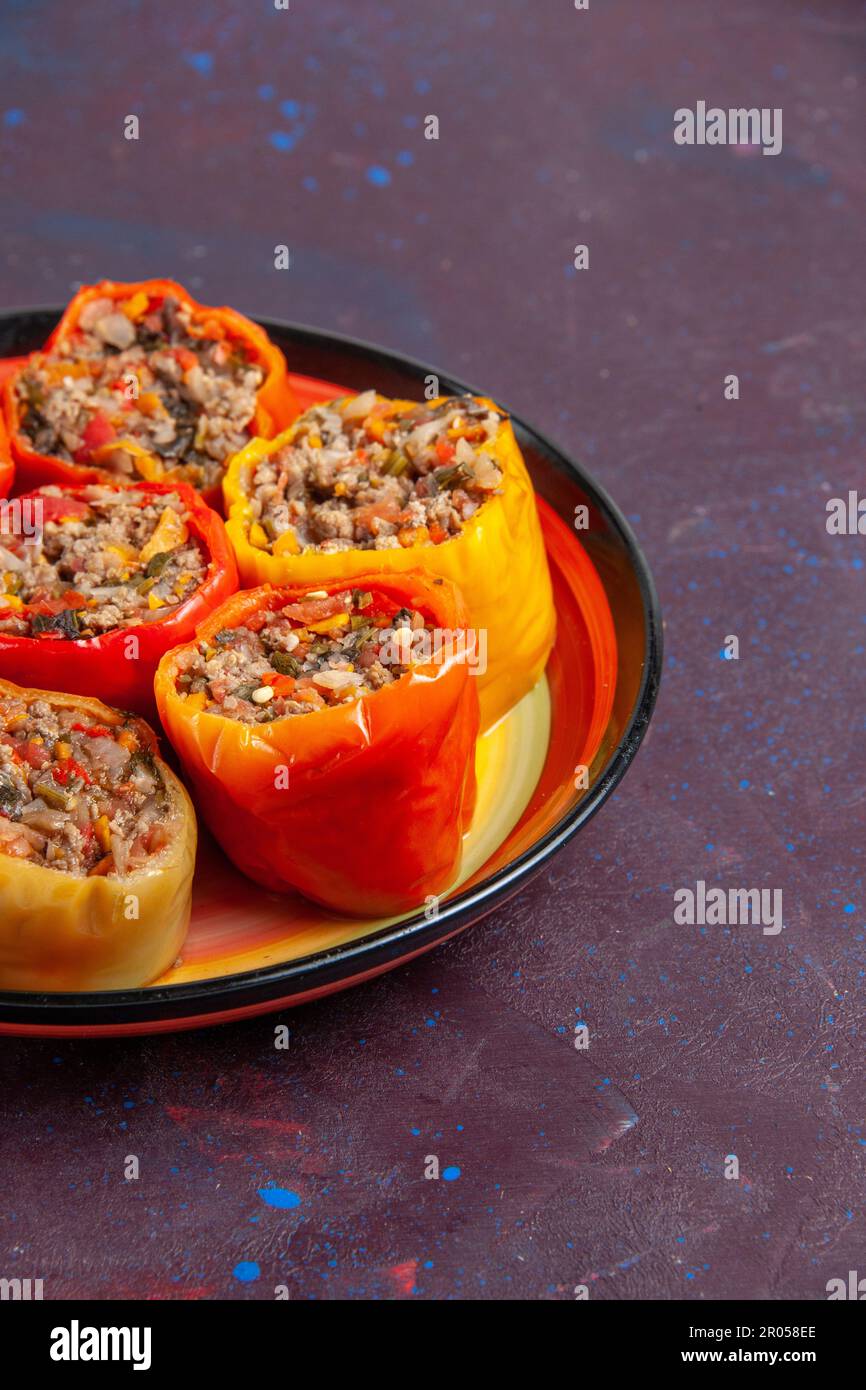 front view cooked bell-peppers with ground meat inside plate on dark ...
