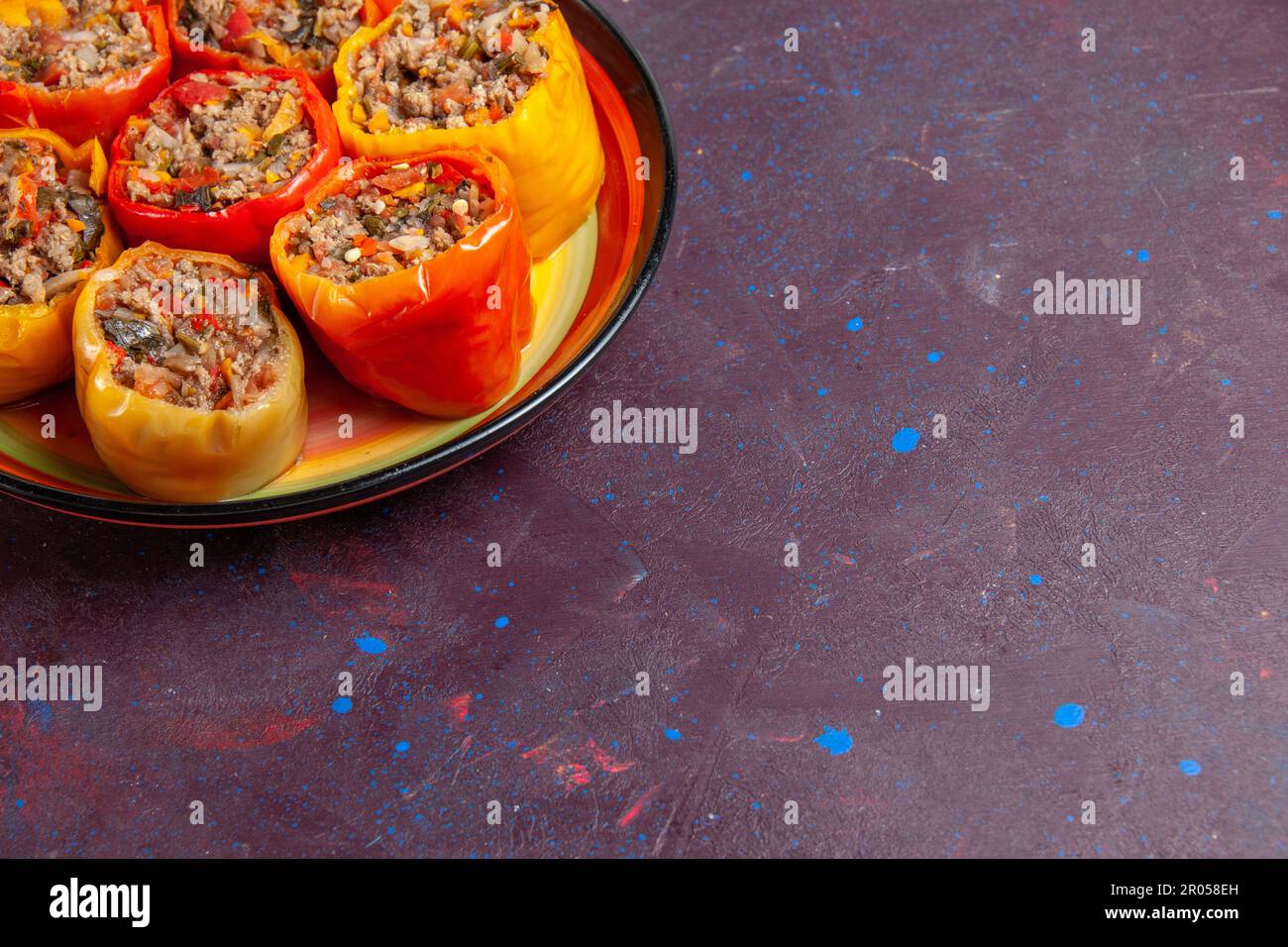 front view cooked bell-peppers with ground meat inside plate on the ...