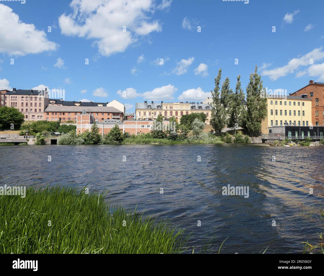 Buildings by a lake during the summer Stock Photo - Alamy