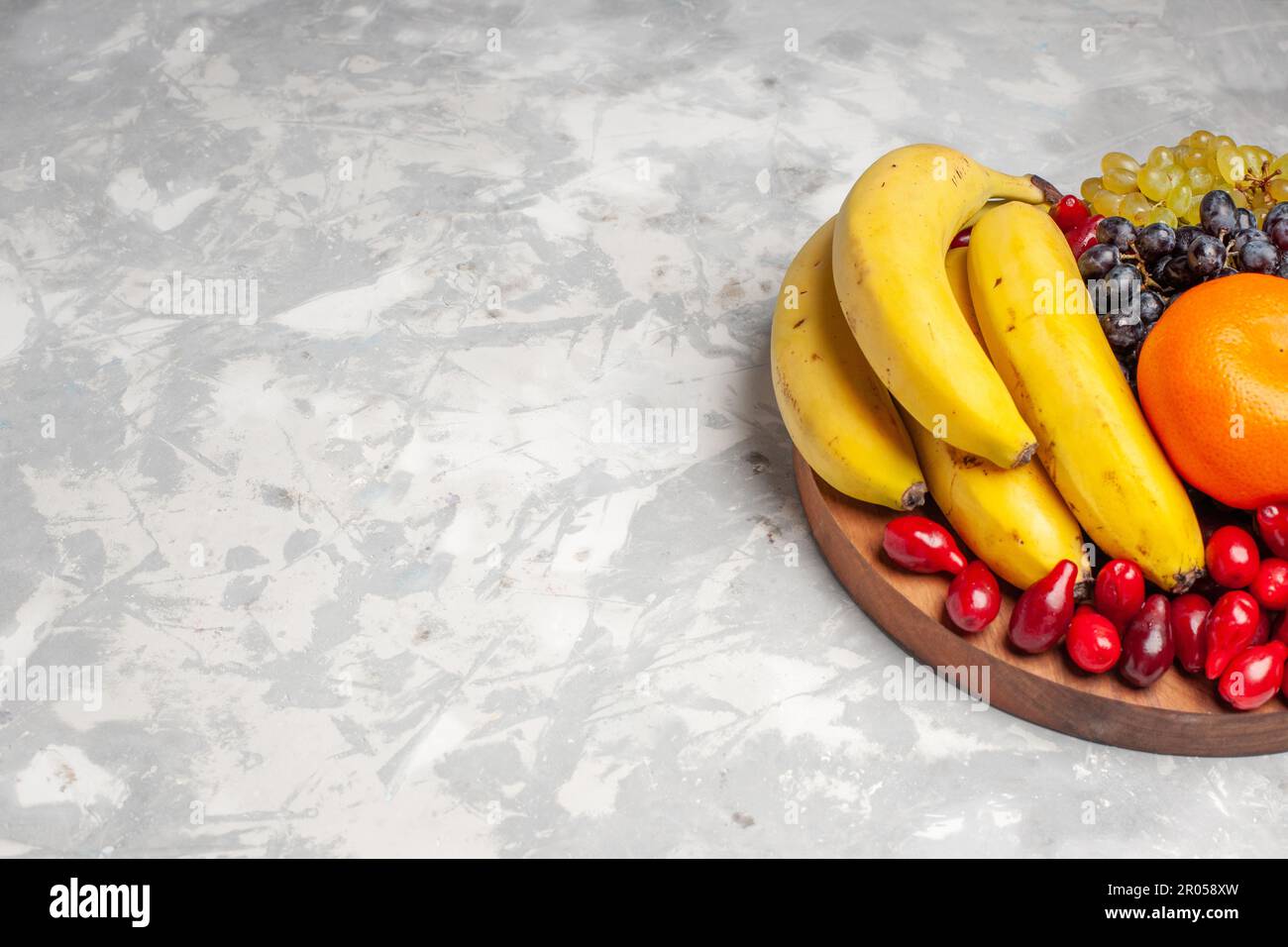 front view fruit composition bananas dogwoods and grapes on light white ...