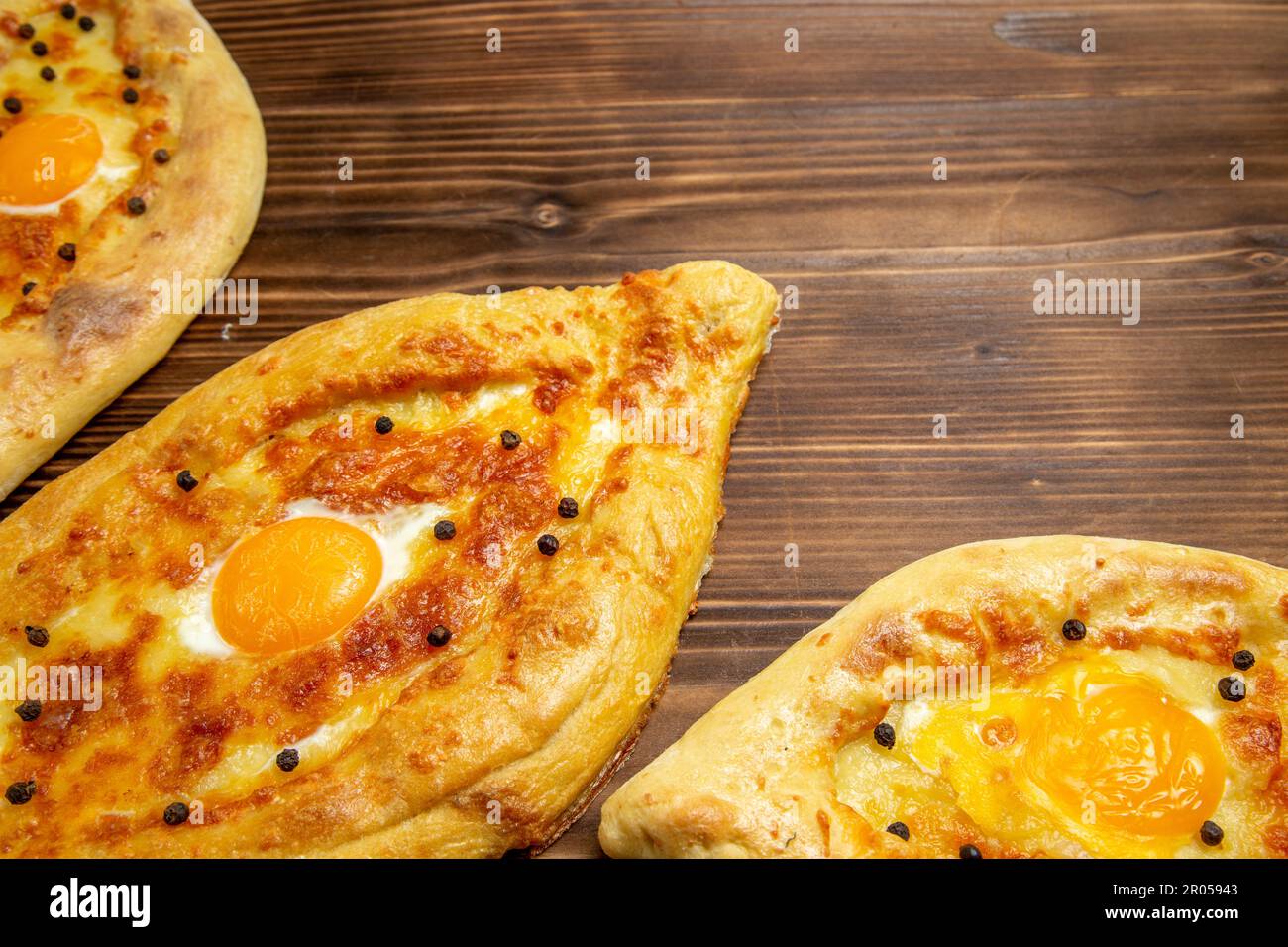 top close view baked egg breads fresh off the oven on brown wooden desk ...