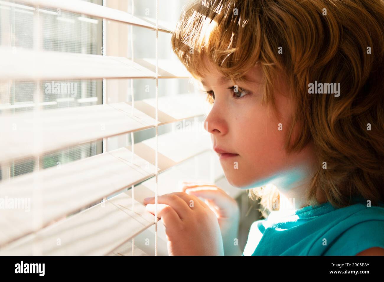 COVID-19 Lockdown. Depressed lonely kid looking through window ...