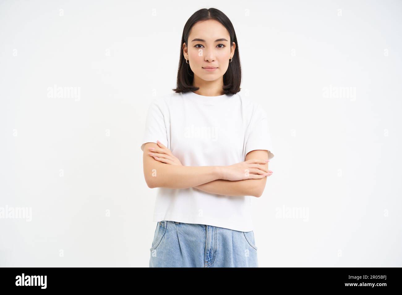 Portrait of asian woman looks with confidence, cross arms on chest ...