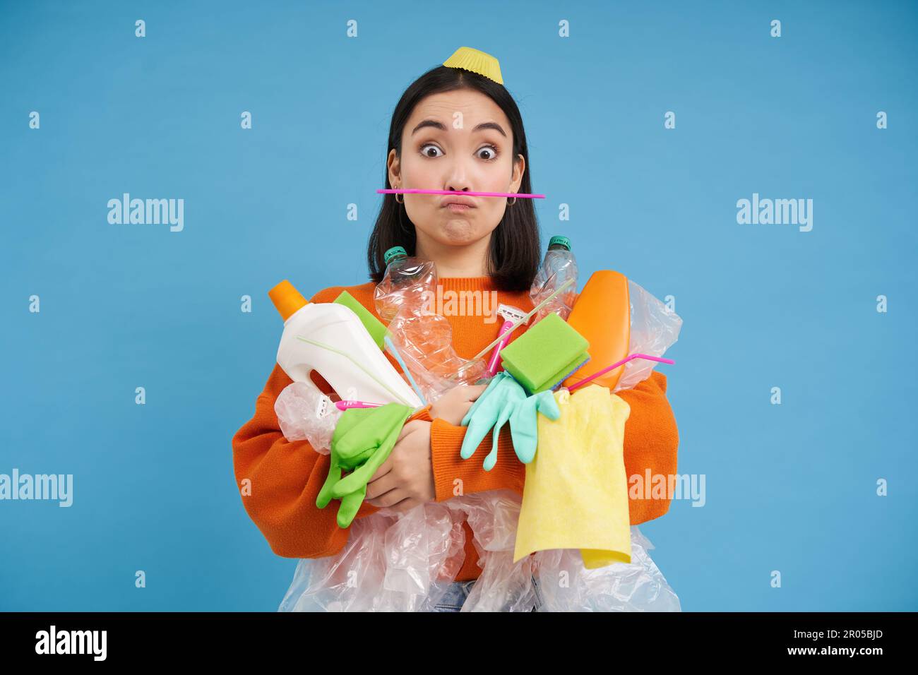 Funny girl holding lots of recycling garbage, plastic waste to recycle ...