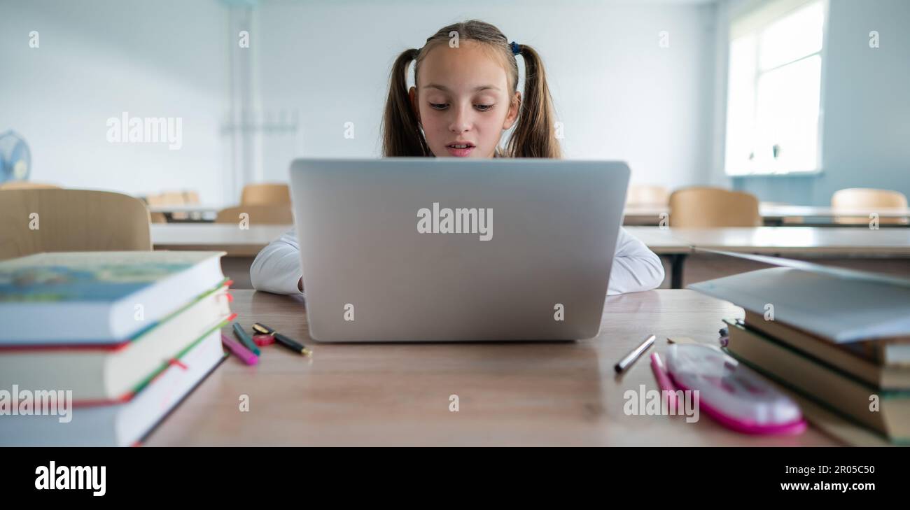 Caucasian girl studying on a laptop in a classroom Stock Photo - Alamy