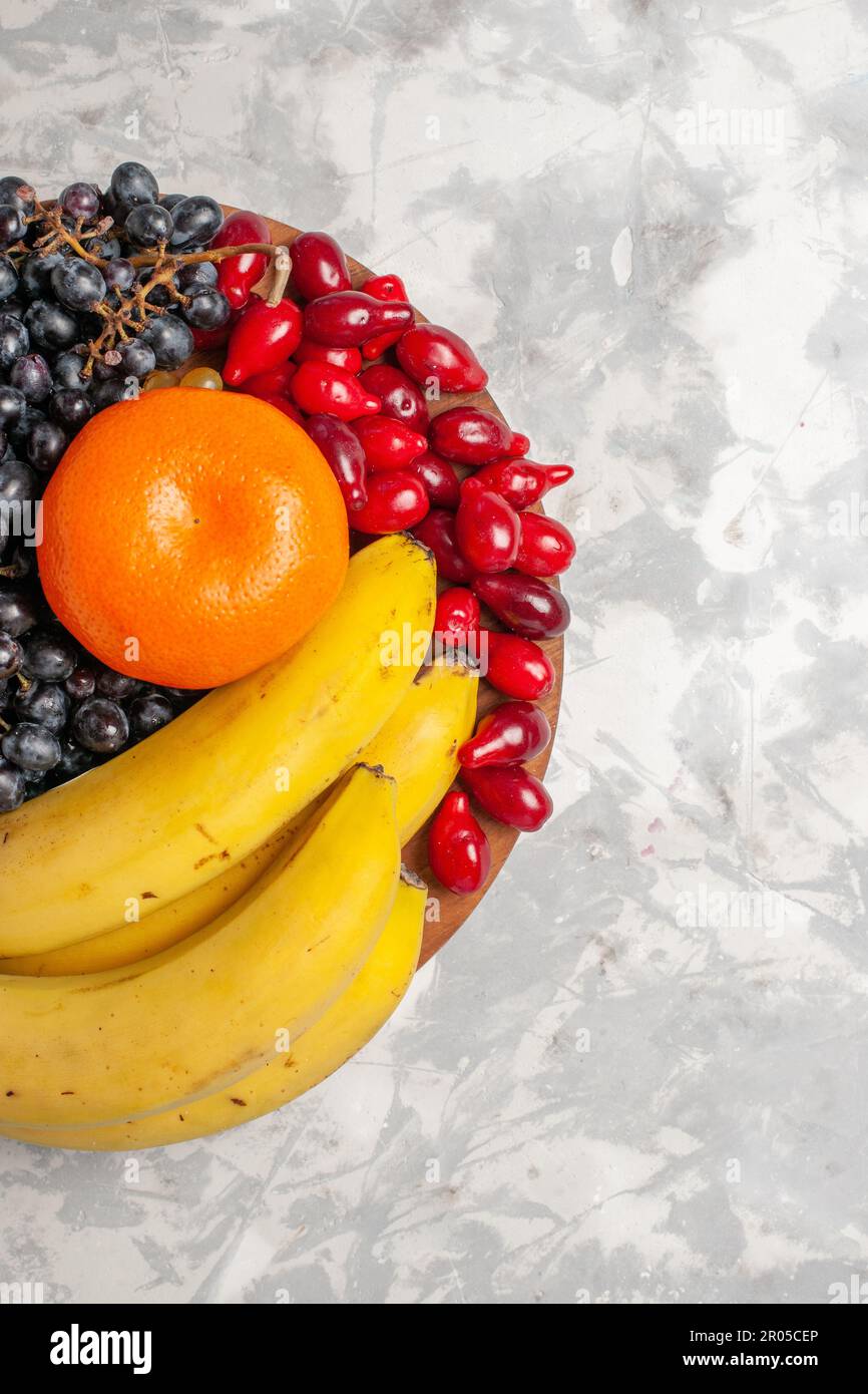 top view fresh fruits composition bananas dogwoods and grapes on white ...