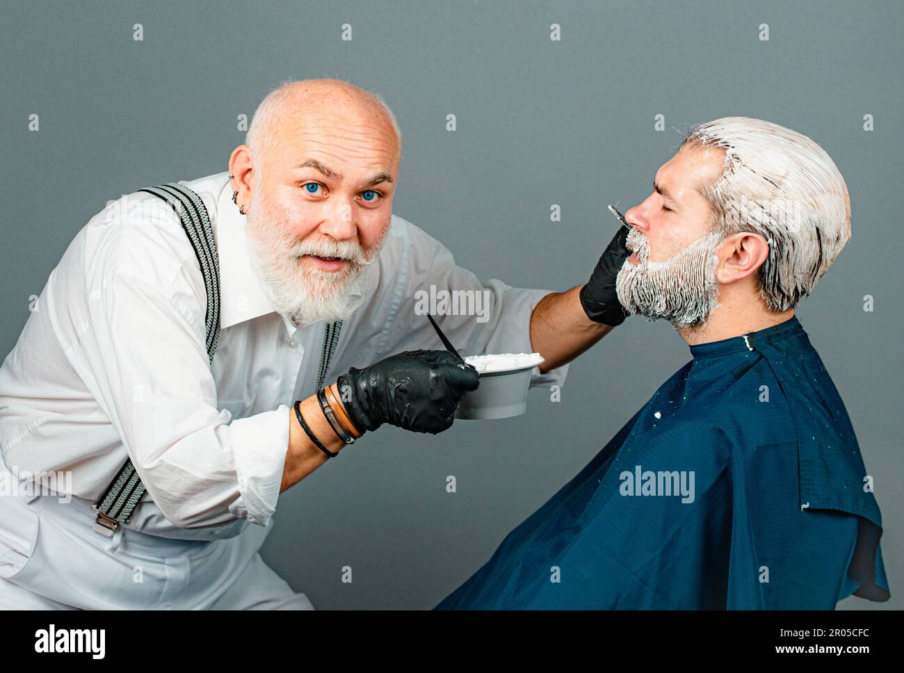 Hairdresser making of a color hair for hipster guy. Process of a man ...