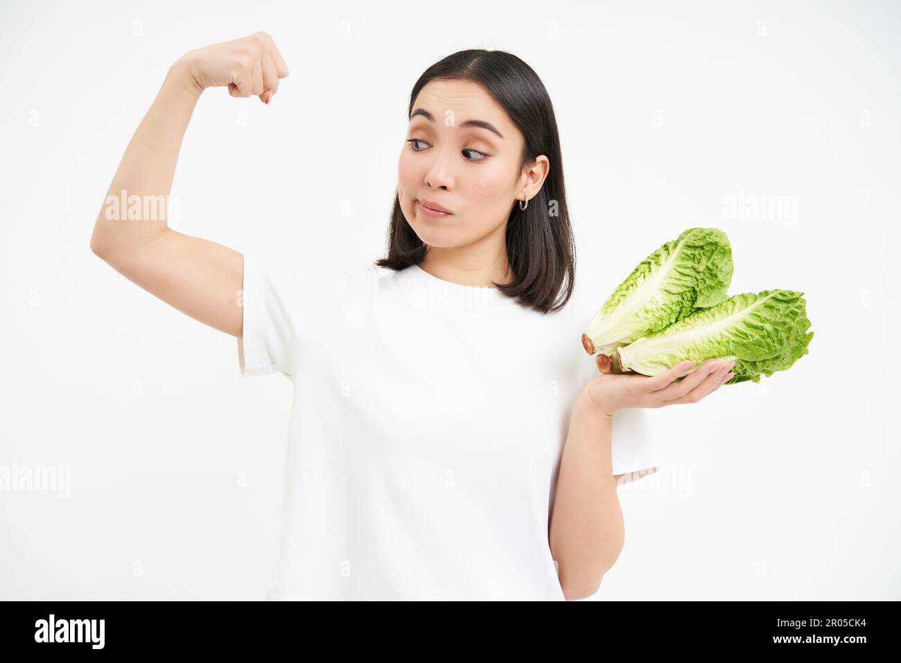 Diet and health. Smiling asian woman shows her biceps, strong body and ...