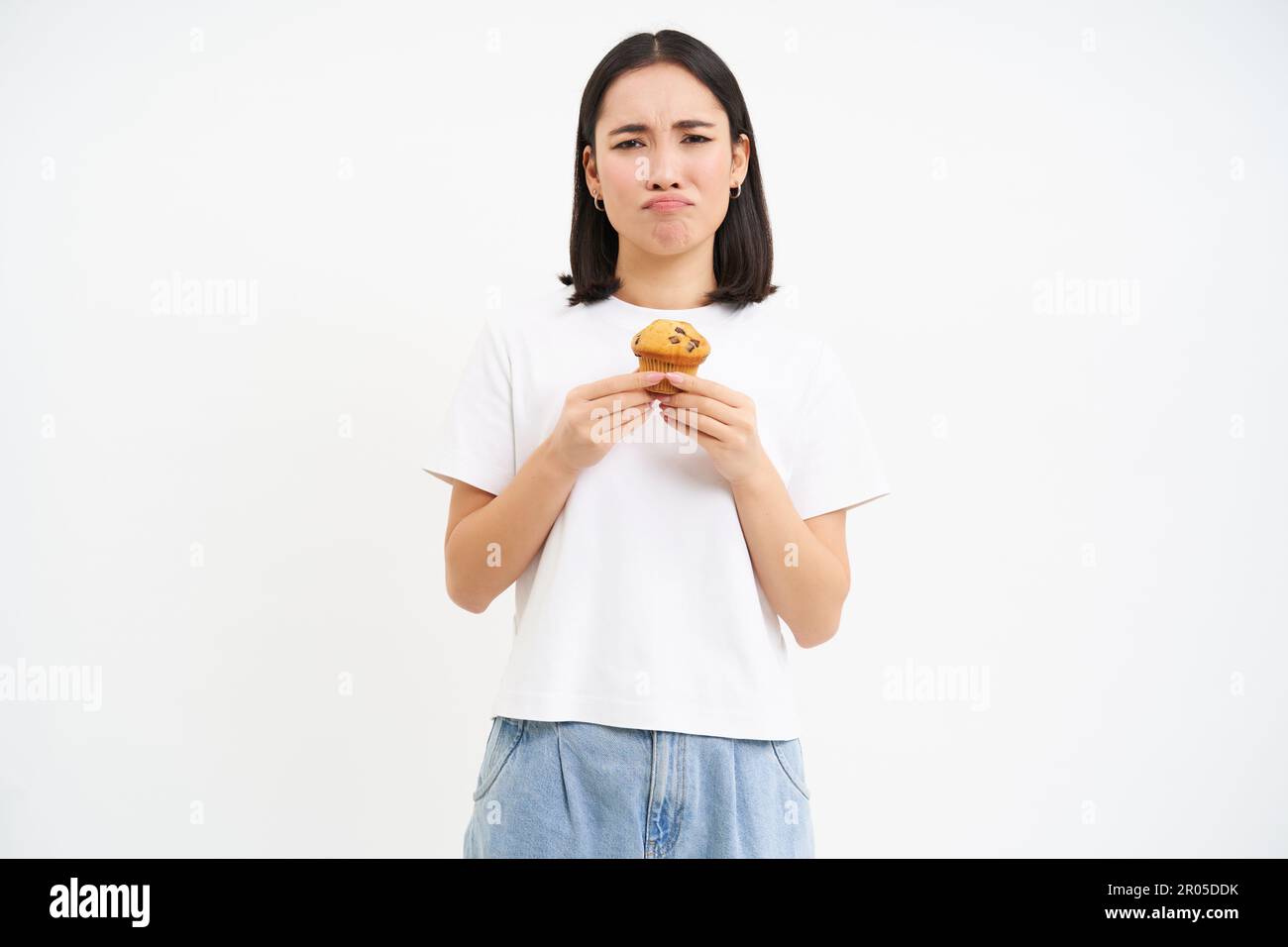 Portrait of miserable girl with cupcake, sad without sweets, cant eat ...