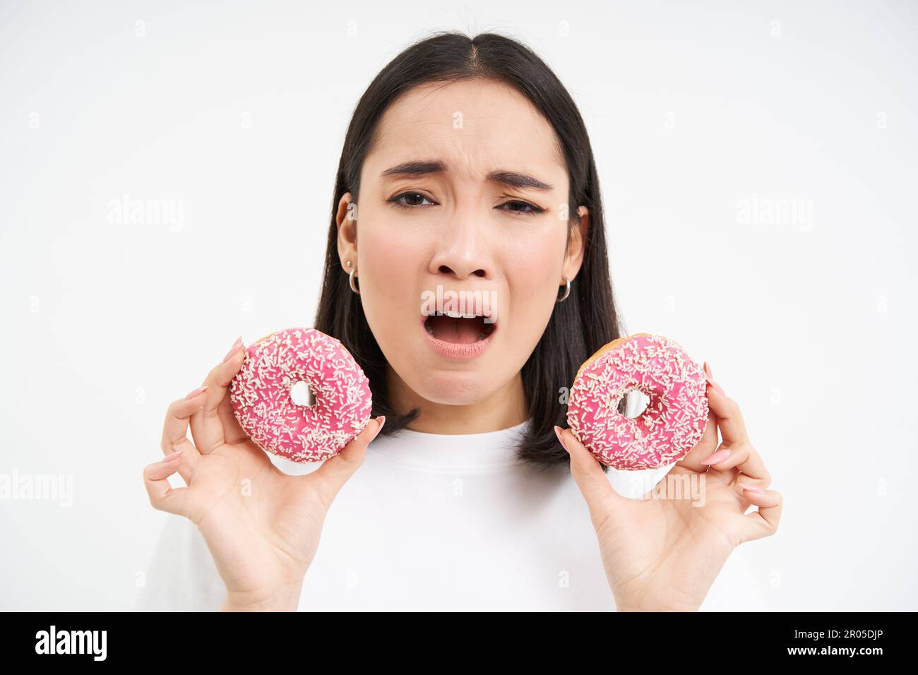 Close up portrait of sad asian woman, upset being on diet, showing two ...