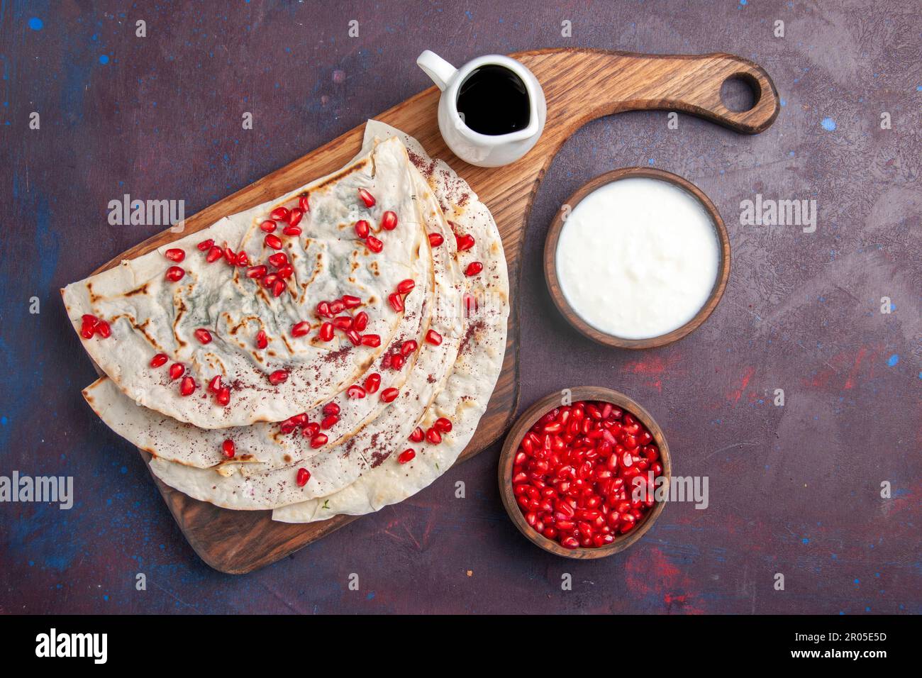 top view tasty meat qutabs pitas with pomegranates on dark-purple ...