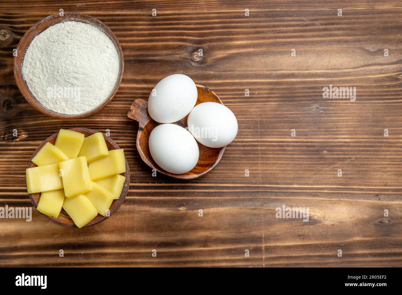 top view whole raw eggs with flour and cheese on brown table egg dough ...