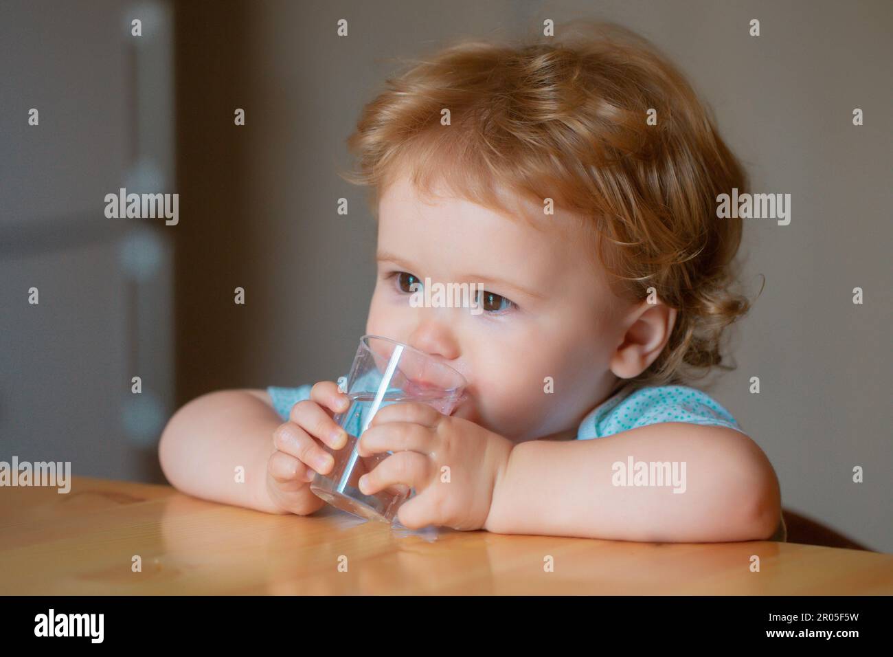 Baby drinking glass of water. Healthy nutrition for kids. Portrait of ...