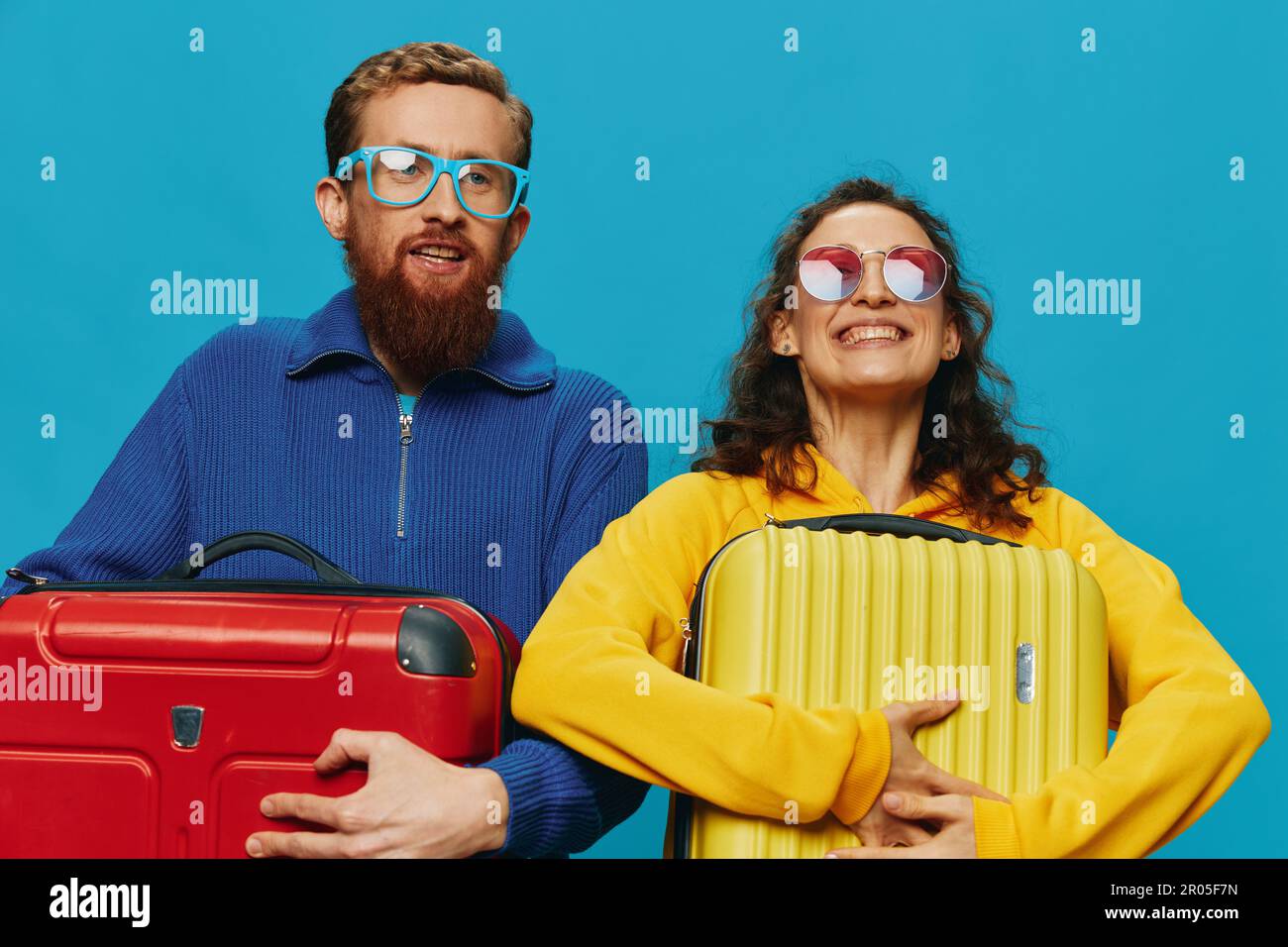 Woman and man smile suitcases in hand with yellow and red suitcase ...
