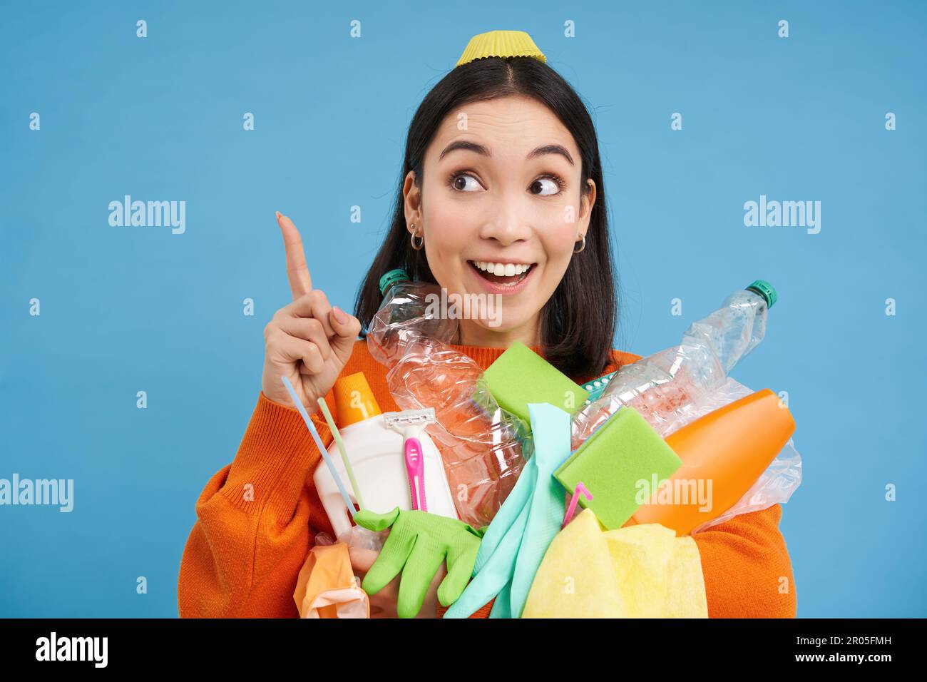 Enthusiastic asian woman, holding plastic empty bottles and garbage for ...