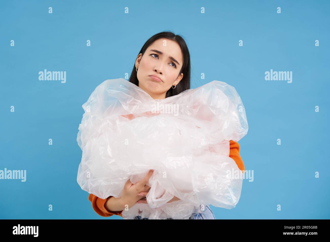 Asian sad woman holding plastic garbage and frowning from ...