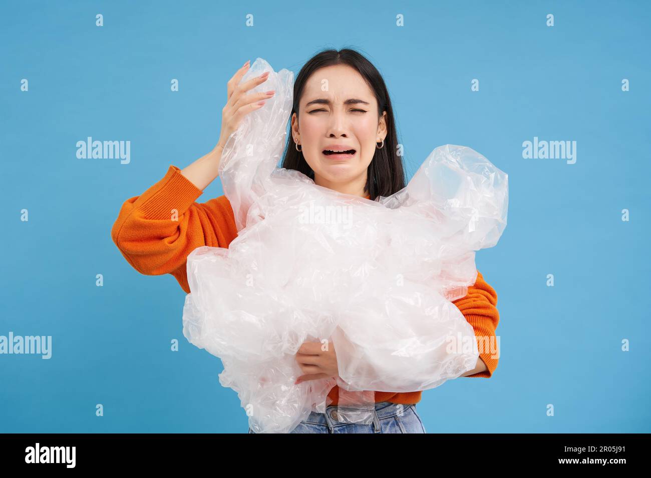 Crying asian woman with plastic recycling waste, tired of sorting ...