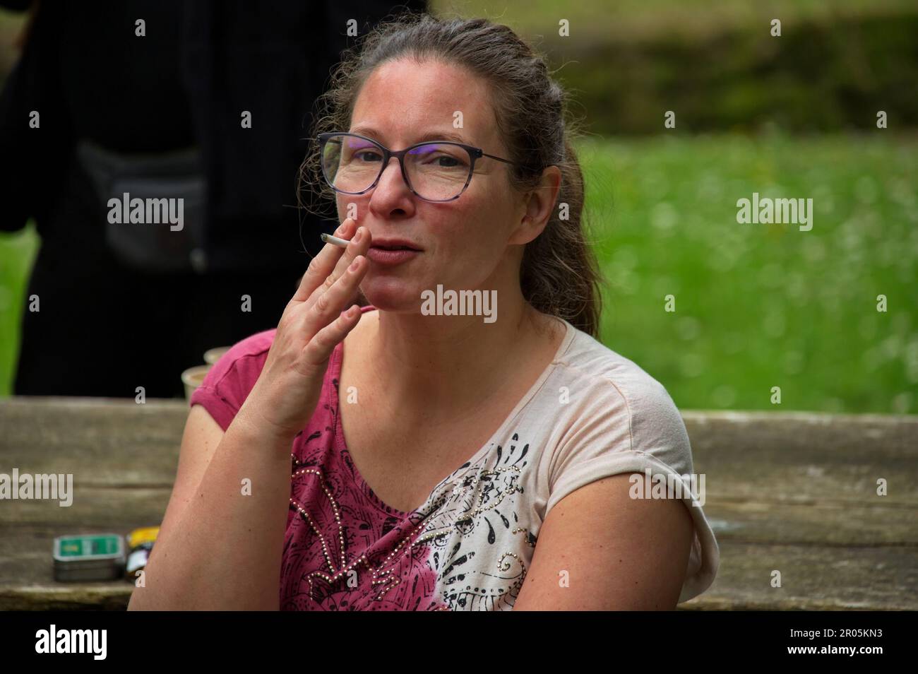 Portrait of mature woman smoking cigarette in nature Stock Photo - Alamy