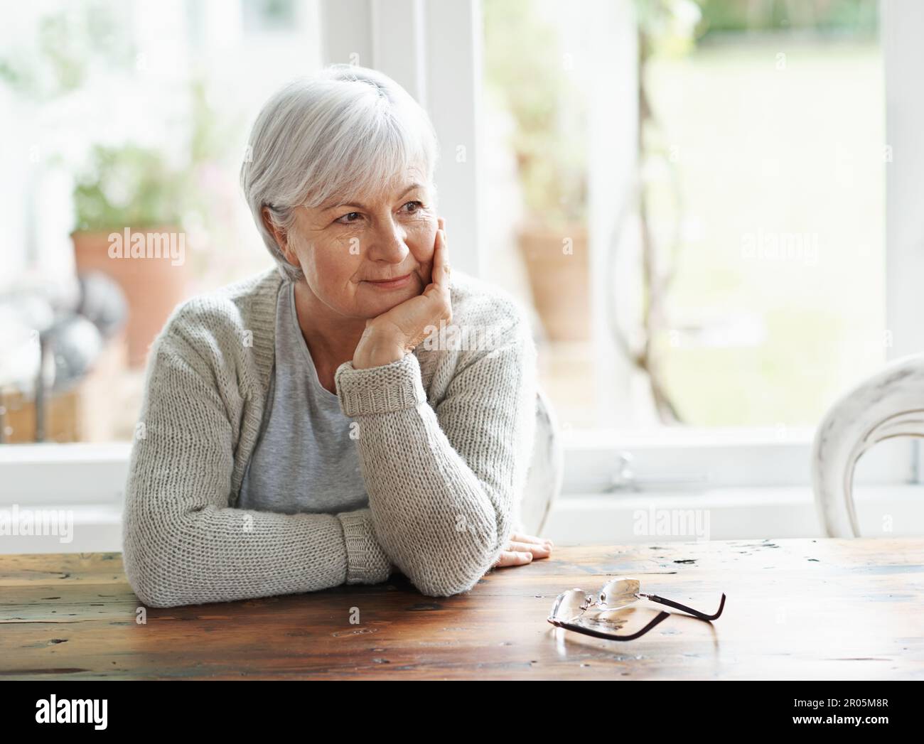 Senior woman, home and thinking of nostalgia, memory and relaxing retirement with hope for ...