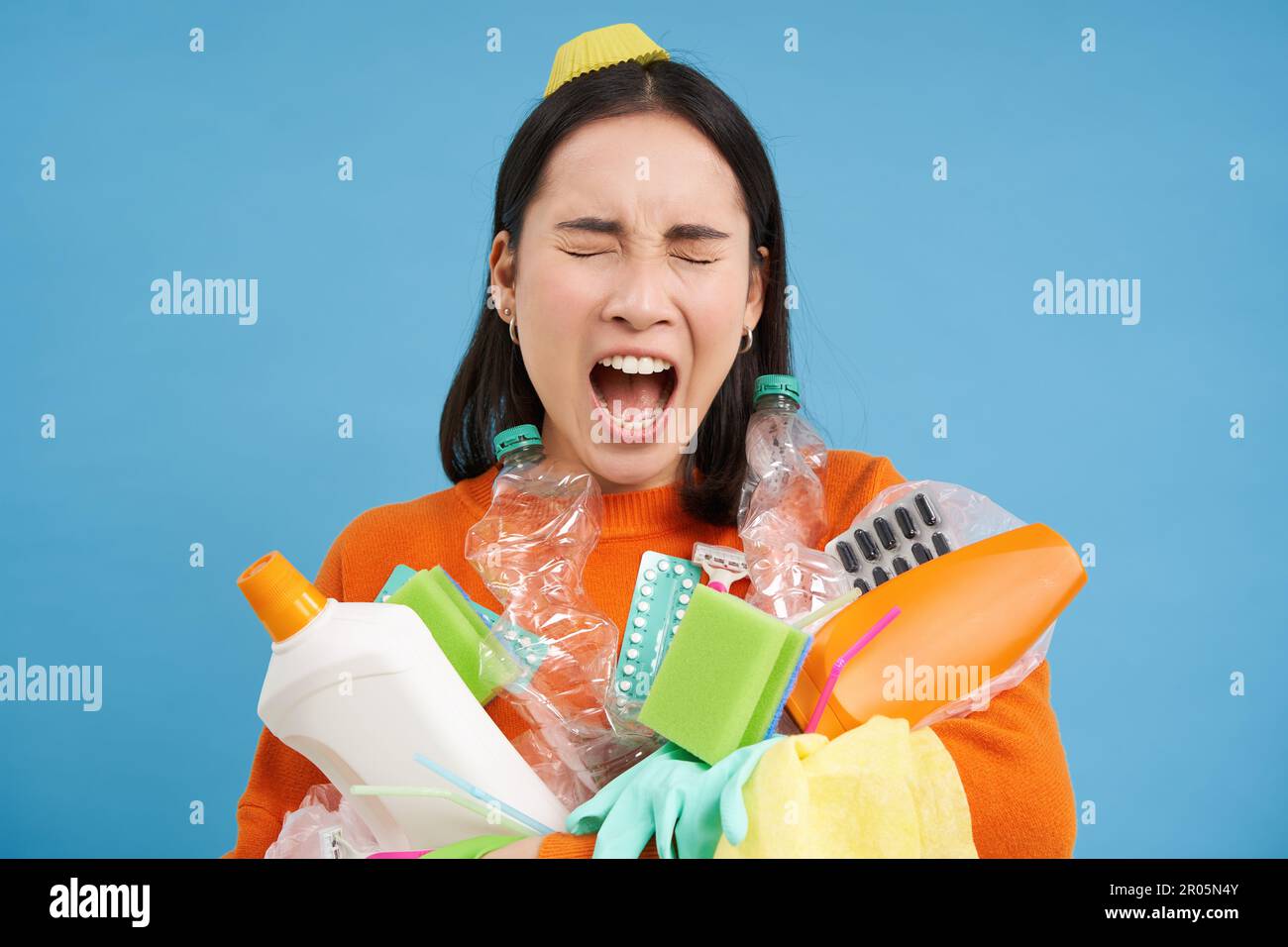 Portrait of crying sad girl with plastic trash, collects recycling ...