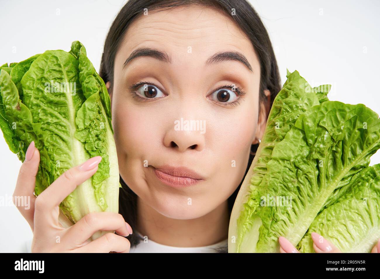 Close up portrait of young korean woman, holds lettuce next to healthy ...