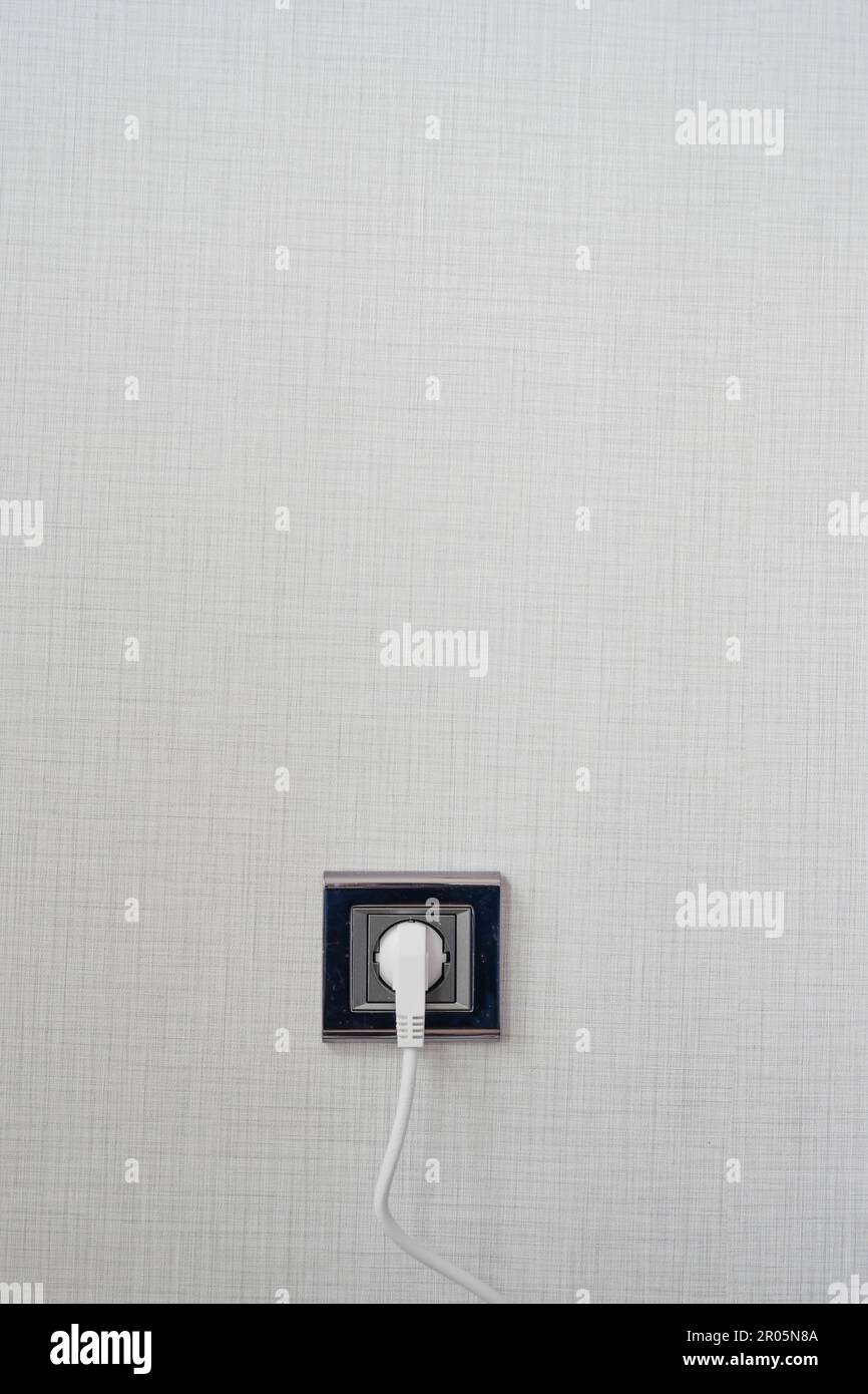 white color power cord cable plugged into wall Stock Photo - Alamy