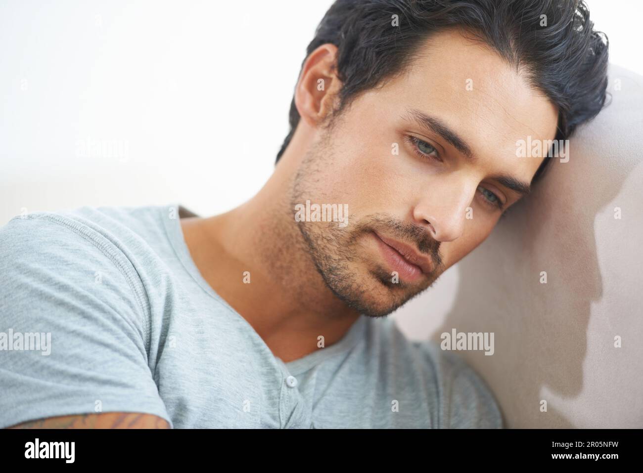 Face, male model and depression or sad, mindful and head on wall while ...