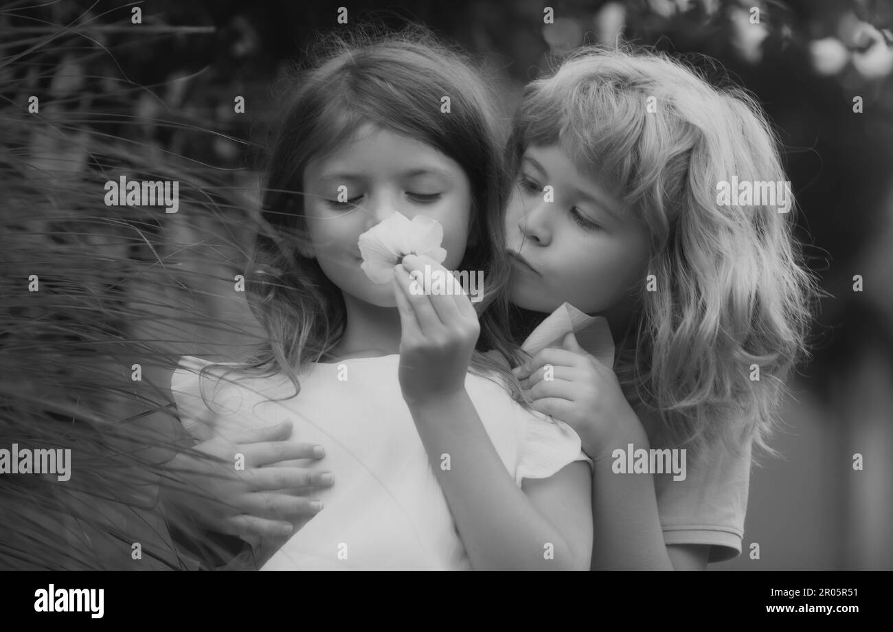 Child boy and girl hugging each other with love in the spring garden. Two little kids hugging in ...