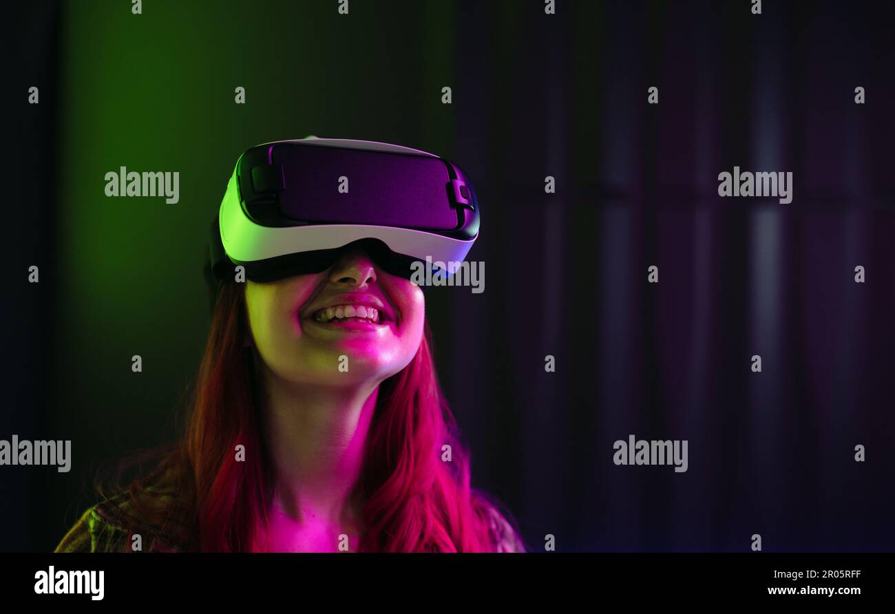 Happy young woman wearing a virtual reality headset. The immersive ...