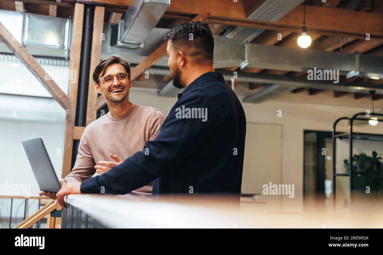 Two business men talking to each other about their tech work. business ...