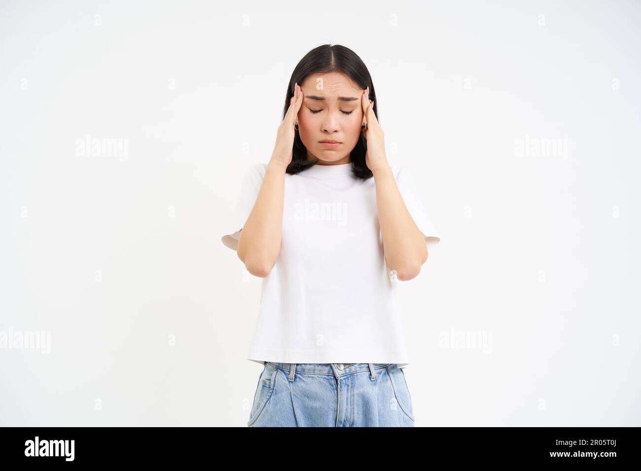 Sad woman holds hands on head, suffers headache, has migraine, feels ...