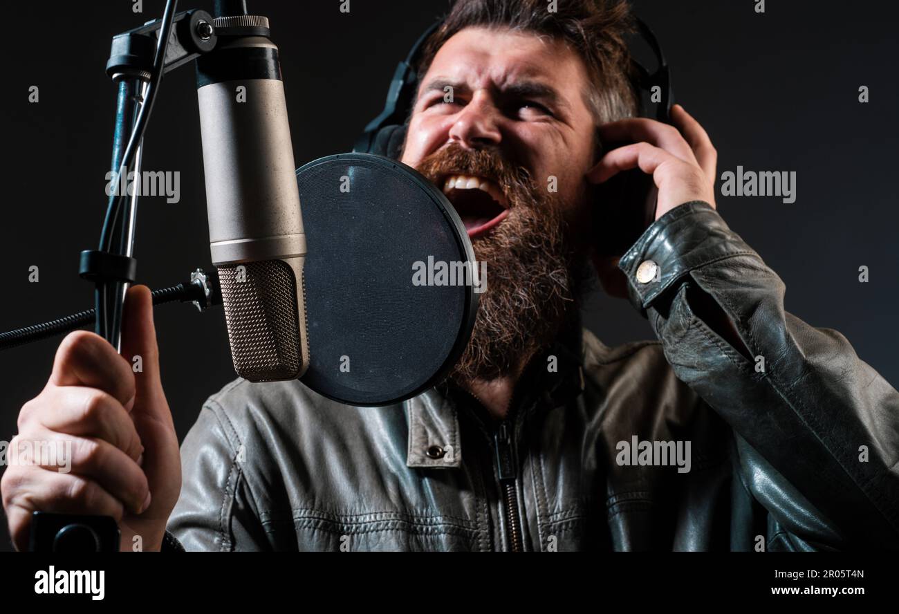 Man with microphone singing song. Musician in music hall. Funny guy ...
